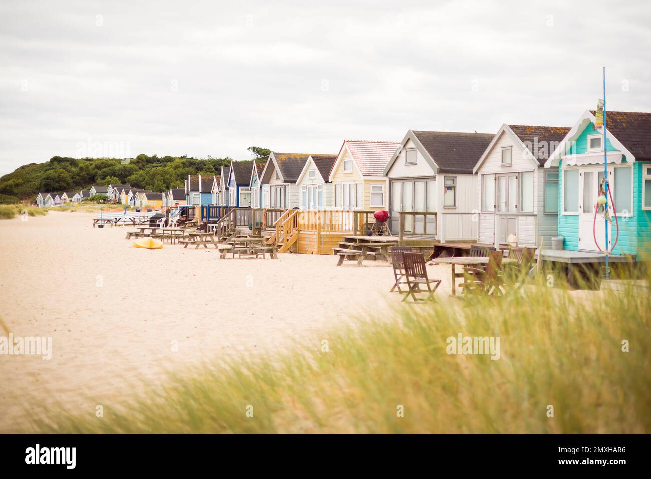 Row of wooden beach huts between sand dunes. Hengistbury Head, Dorset ...