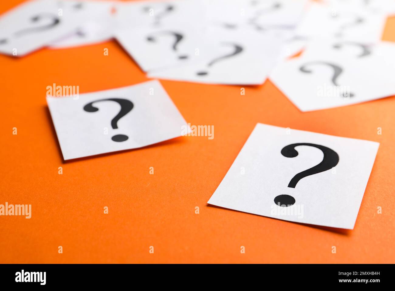 Paper notes with question marks on orange background, closeup Stock ...