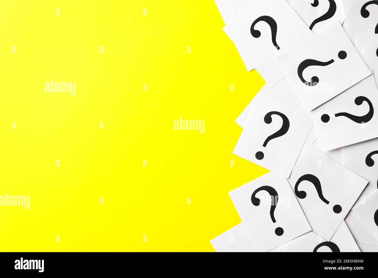 Paper notes with question marks on yellow background, flat lay. Space ...