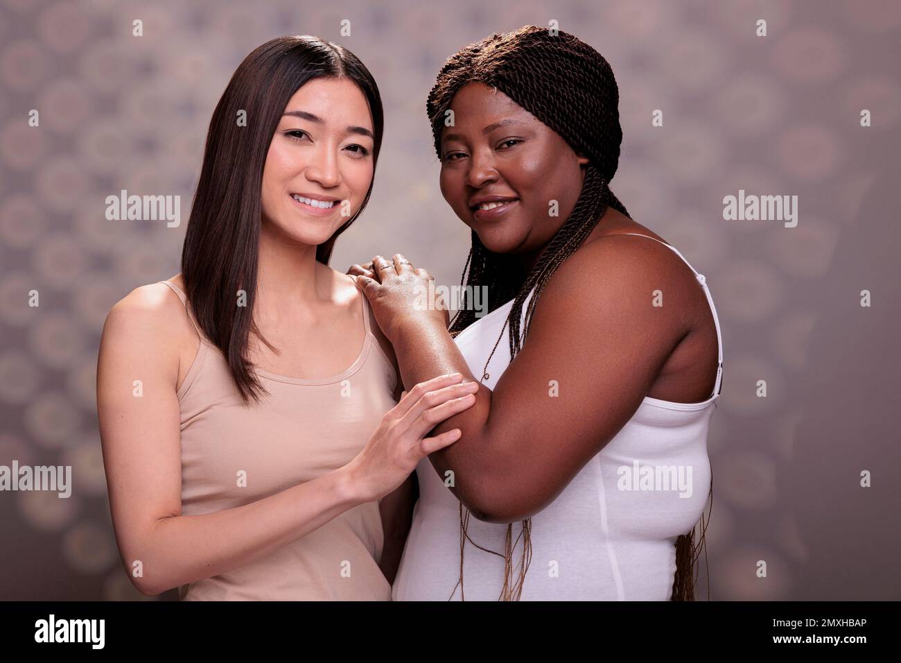 Smiling asian and african american beautiful women posing together ...