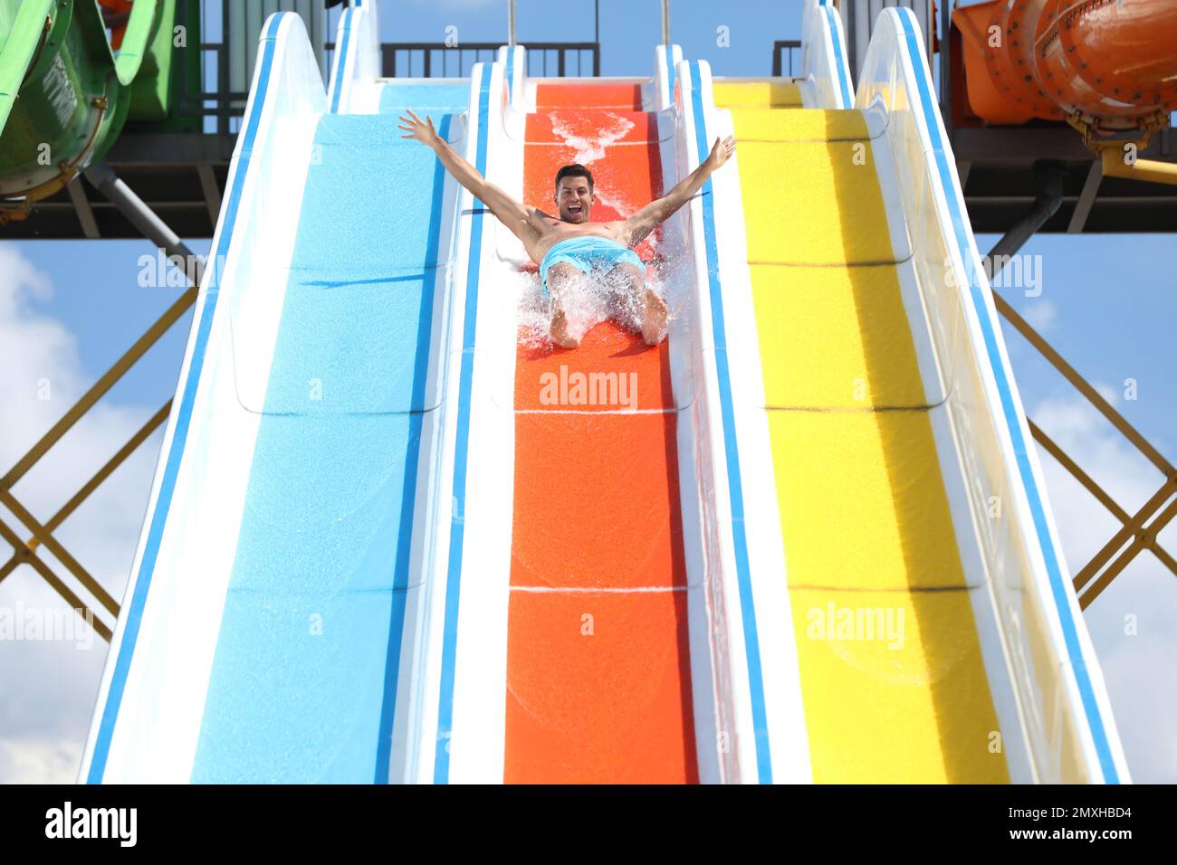 Man on slide at water park. Summer vacation Stock Photo - Alamy