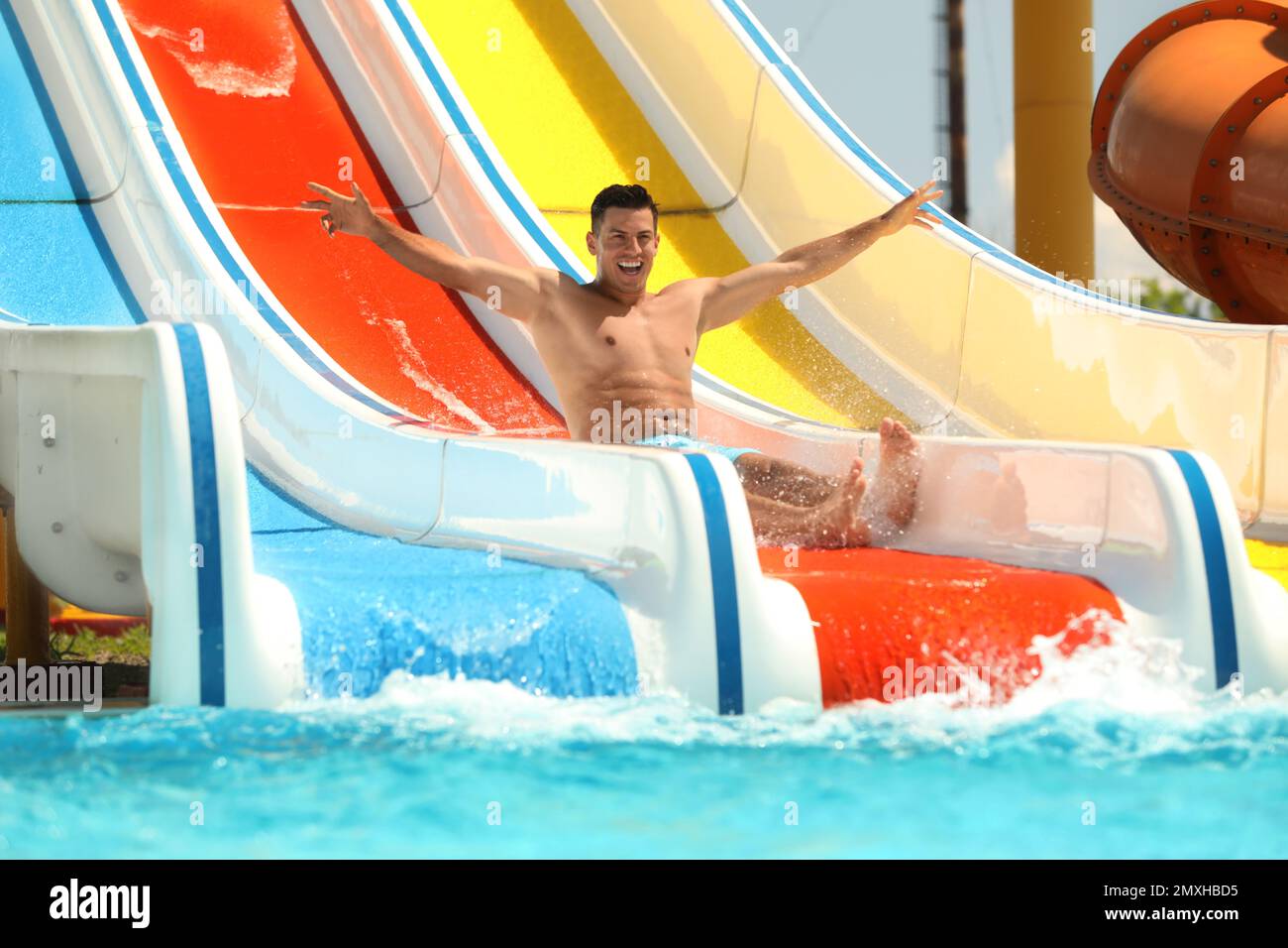 Man on slide at water park. Summer vacation Stock Photo - Alamy
