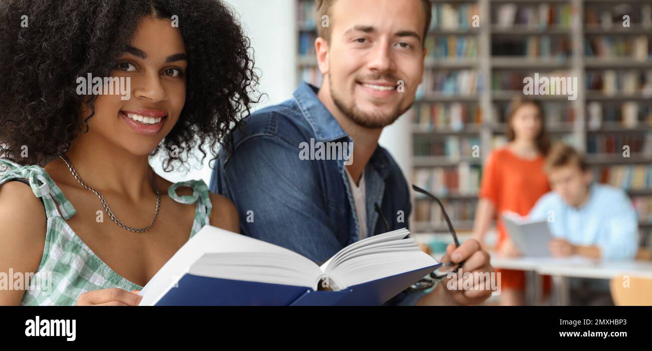 Young students with book in modern library. Banner design Stock Photo ...