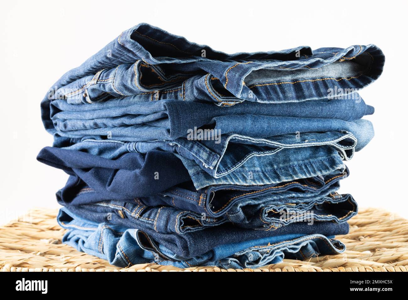 Diverse folded jeans lying in stack on white background Stock Photo - Alamy