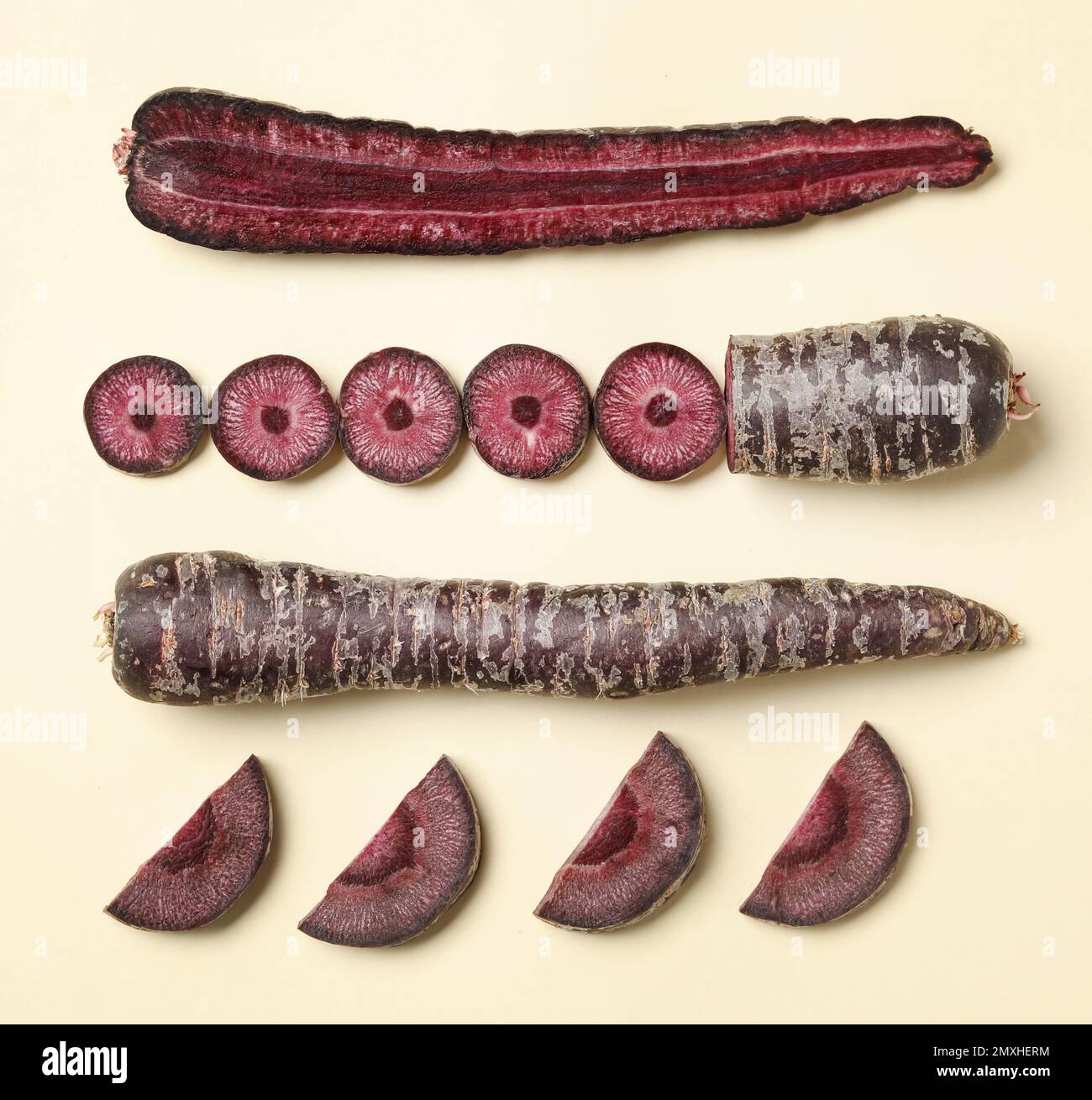 Whole and cut raw purple carrots on beige background, flat lay Stock ...