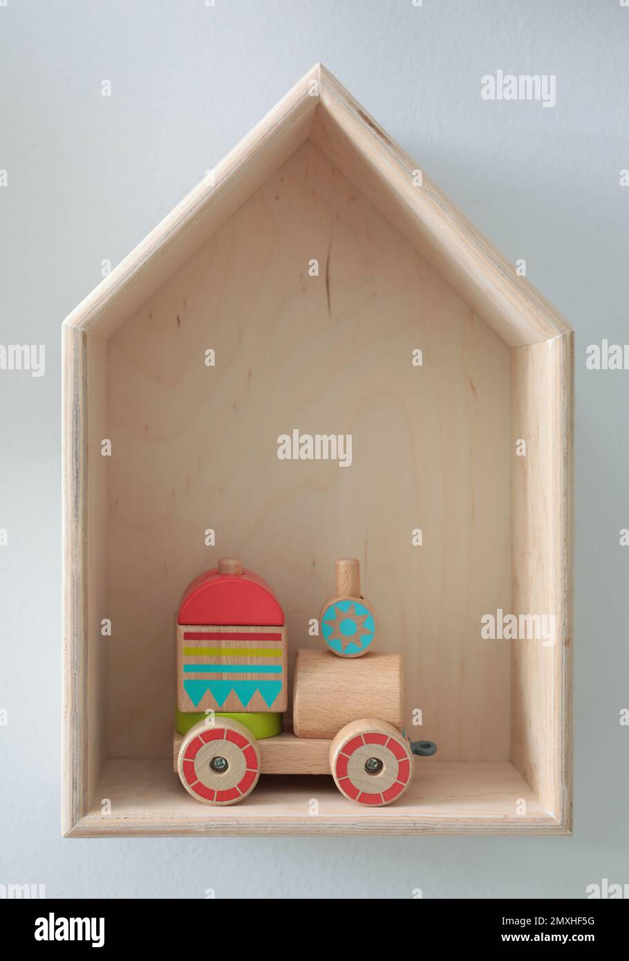 House shaped shelf with toys on white wall. Interior design Stock Photo ...