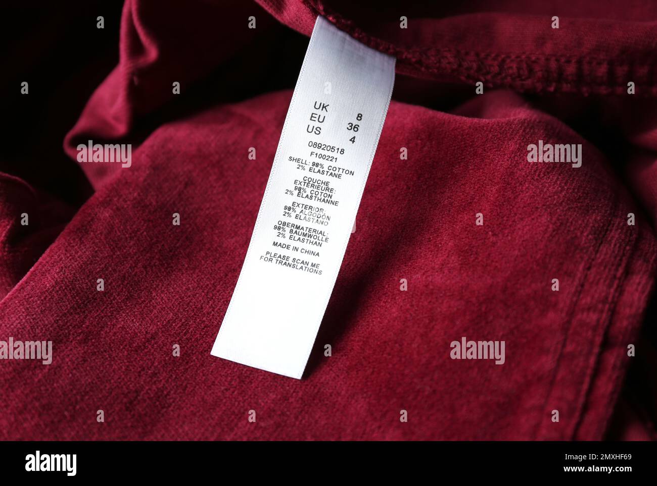 Clothing label with size and content information on red garment ...