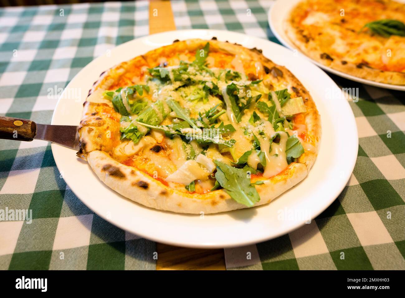 Fresh homemade authentic italian stone oven caesar pizza with arugula, sauce, grilled chicken ...