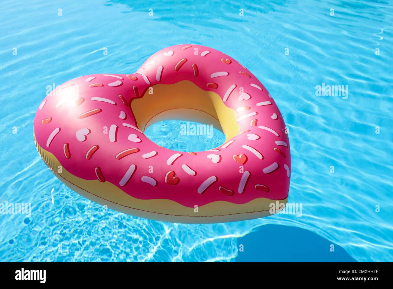 Heart shaped inflatable ring floating in swimming pool. Summer vacation ...
