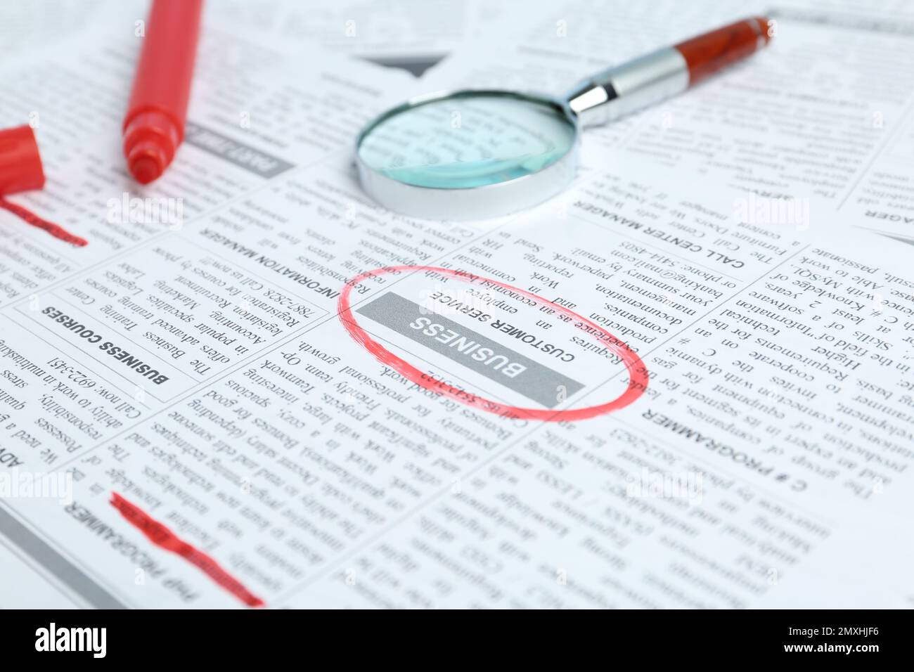 Newspaper with marked advertisement and magnifying glass. Search ...