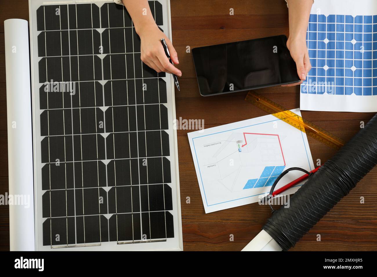 Architect working on house project with solar panels at wooden table ...