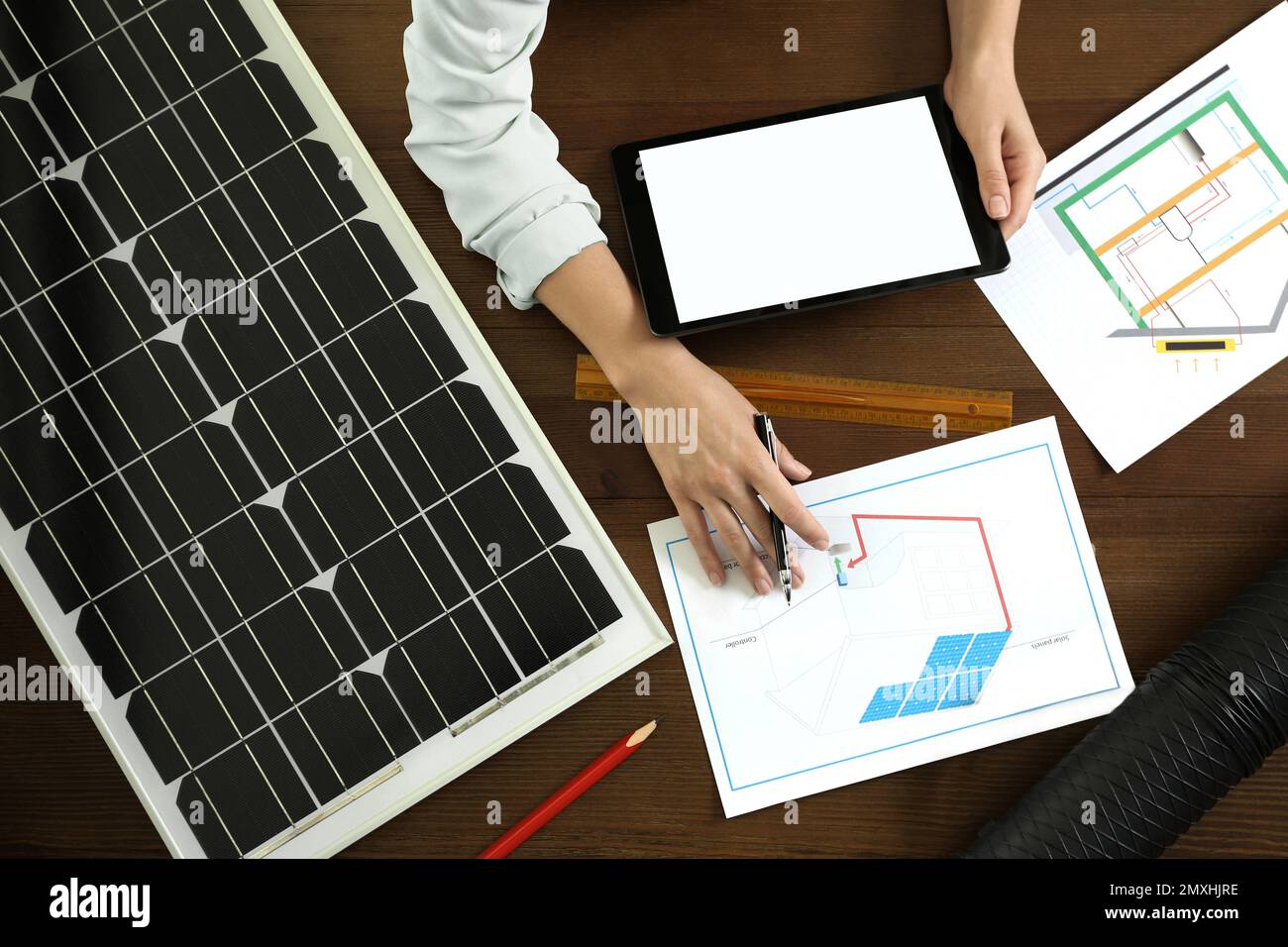 Architect working on house project with solar panels at wooden table ...