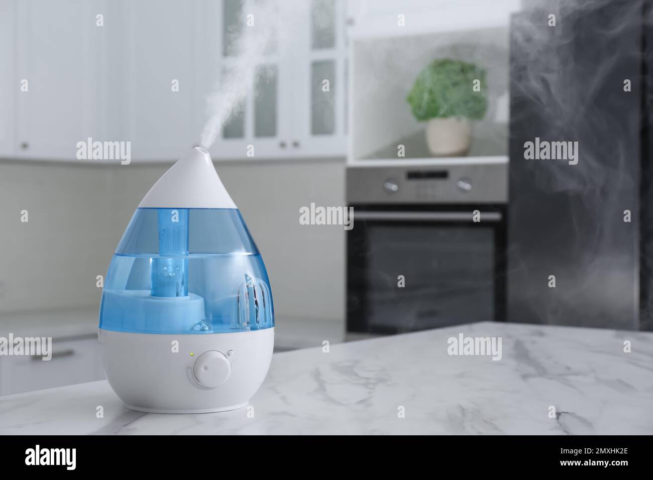 Modern air humidifier on marble table in kitchen. Space for text Stock ...