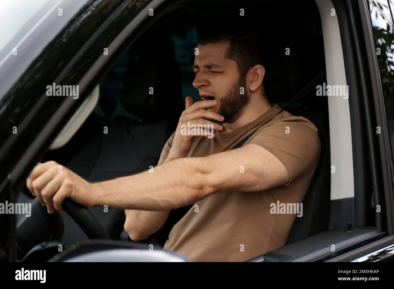 Tired man yawning while driving his modern car Stock Photo - Alamy