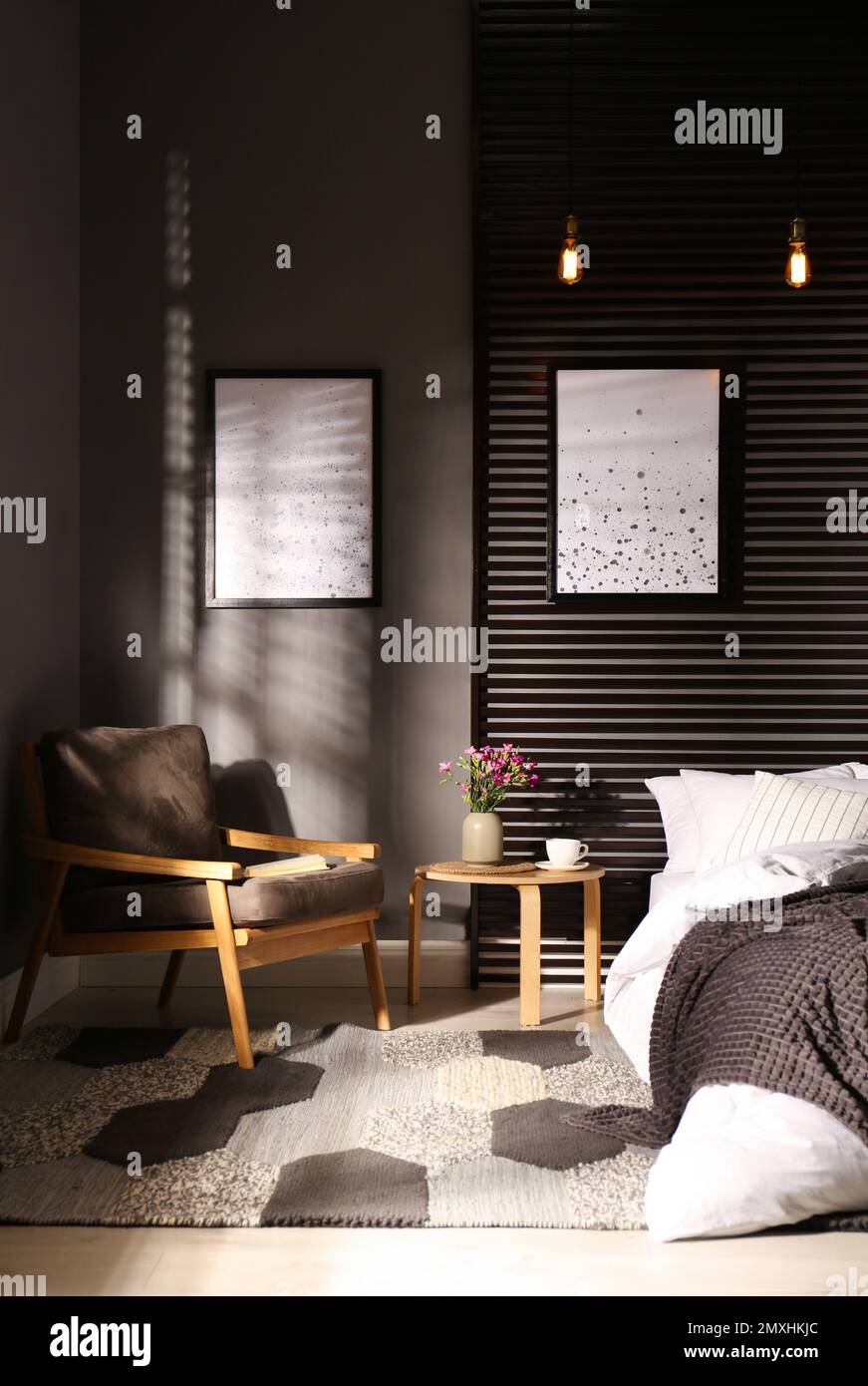Comfortable bedroom with armchair and pictures on wall. Interior design ...
