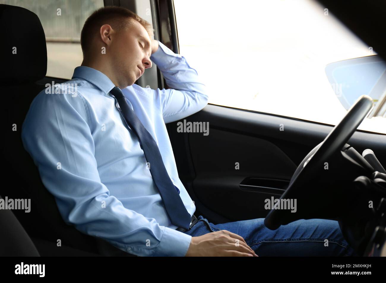 Tired young man sleeping in his modern car Stock Photo - Alamy