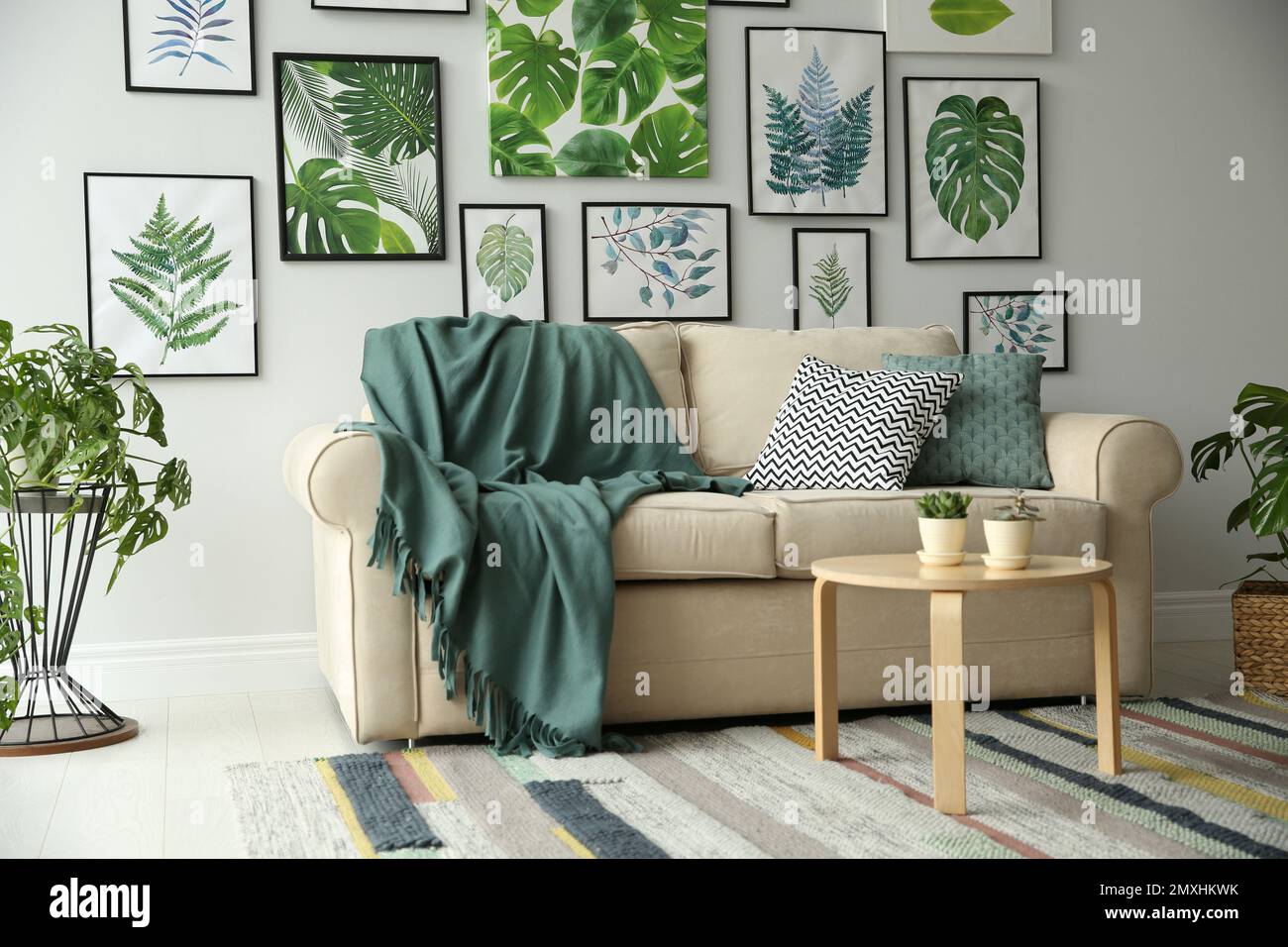 Beautiful artworks and comfortable couch in stylish room. Interior ...