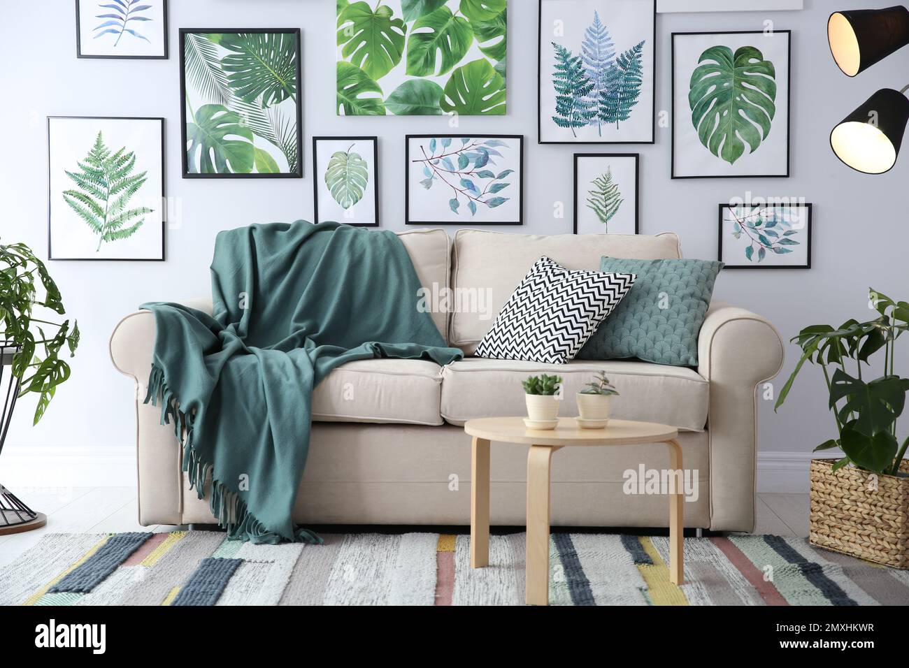 Beautiful artworks and comfortable couch in stylish room. Interior ...