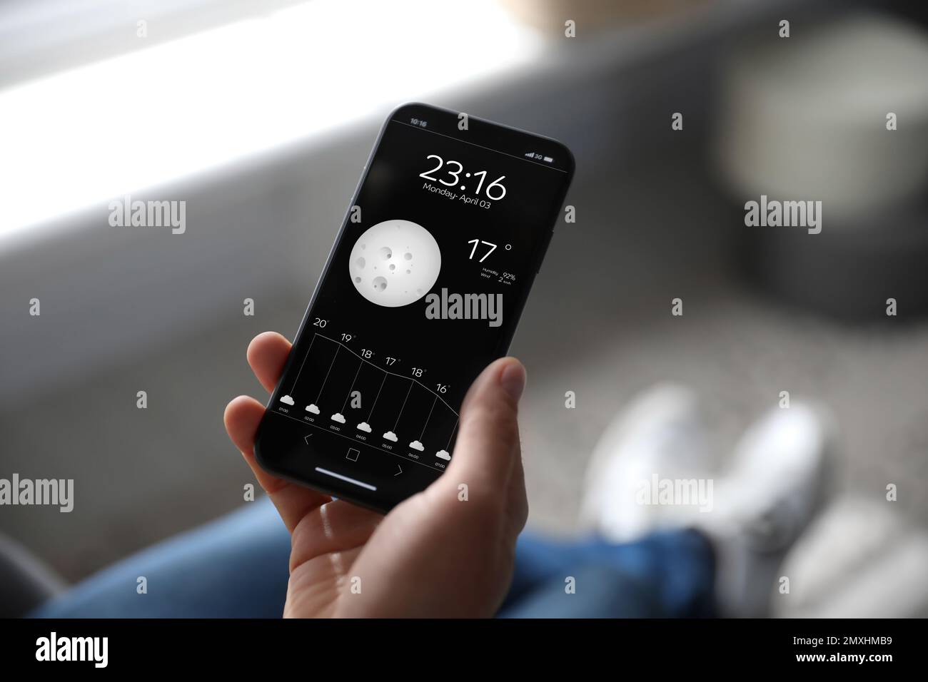 Man using weather forecast app on smartphone indoors, closeup Stock ...