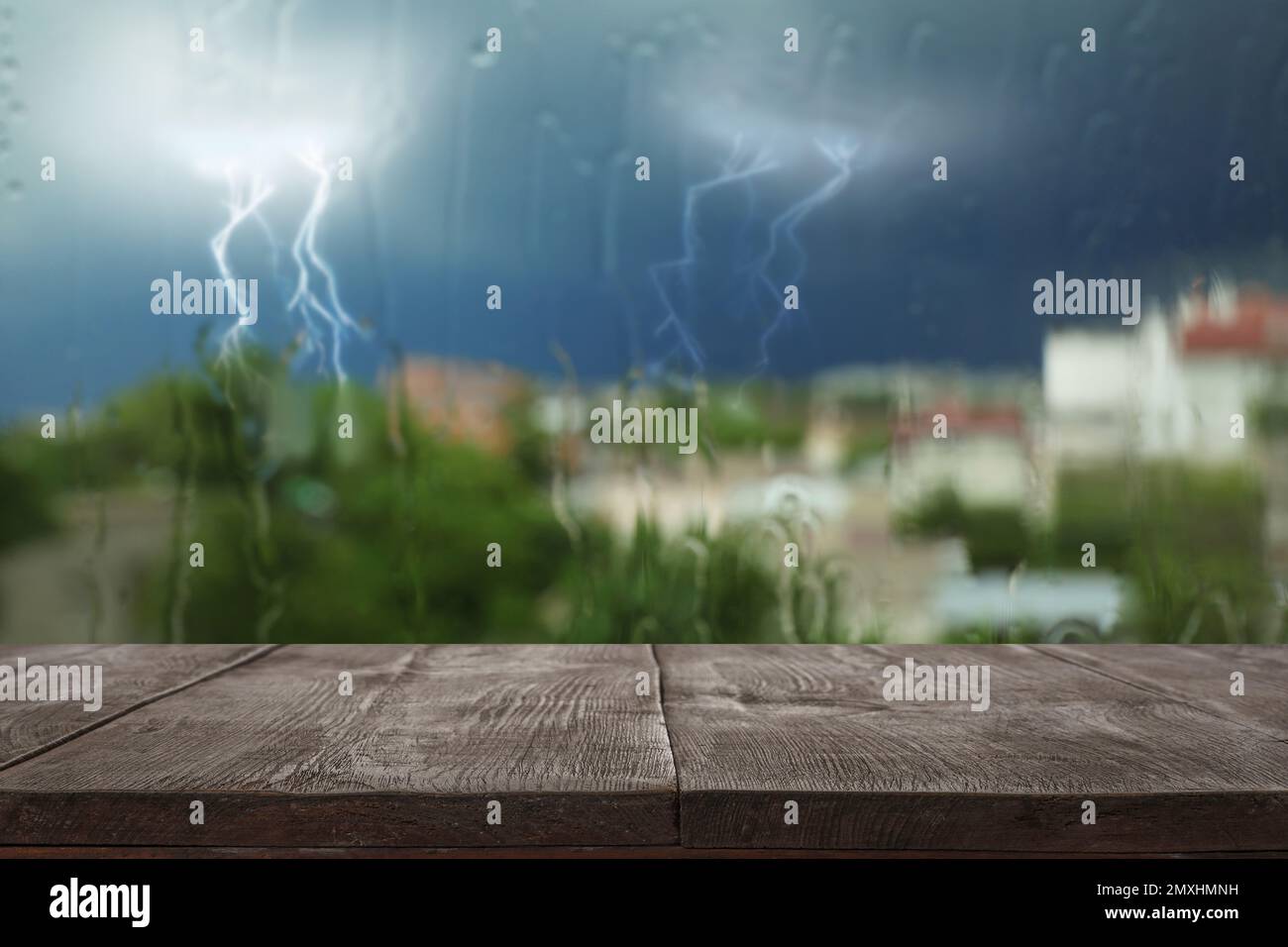 Wooden table near window on rainy day Stock Photo - Alamy
