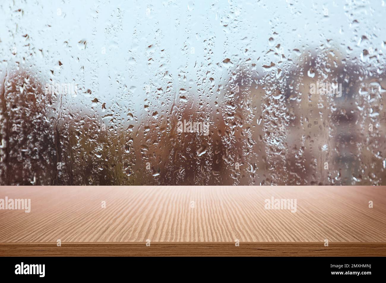 Wooden table near window on rainy day Stock Photo - Alamy