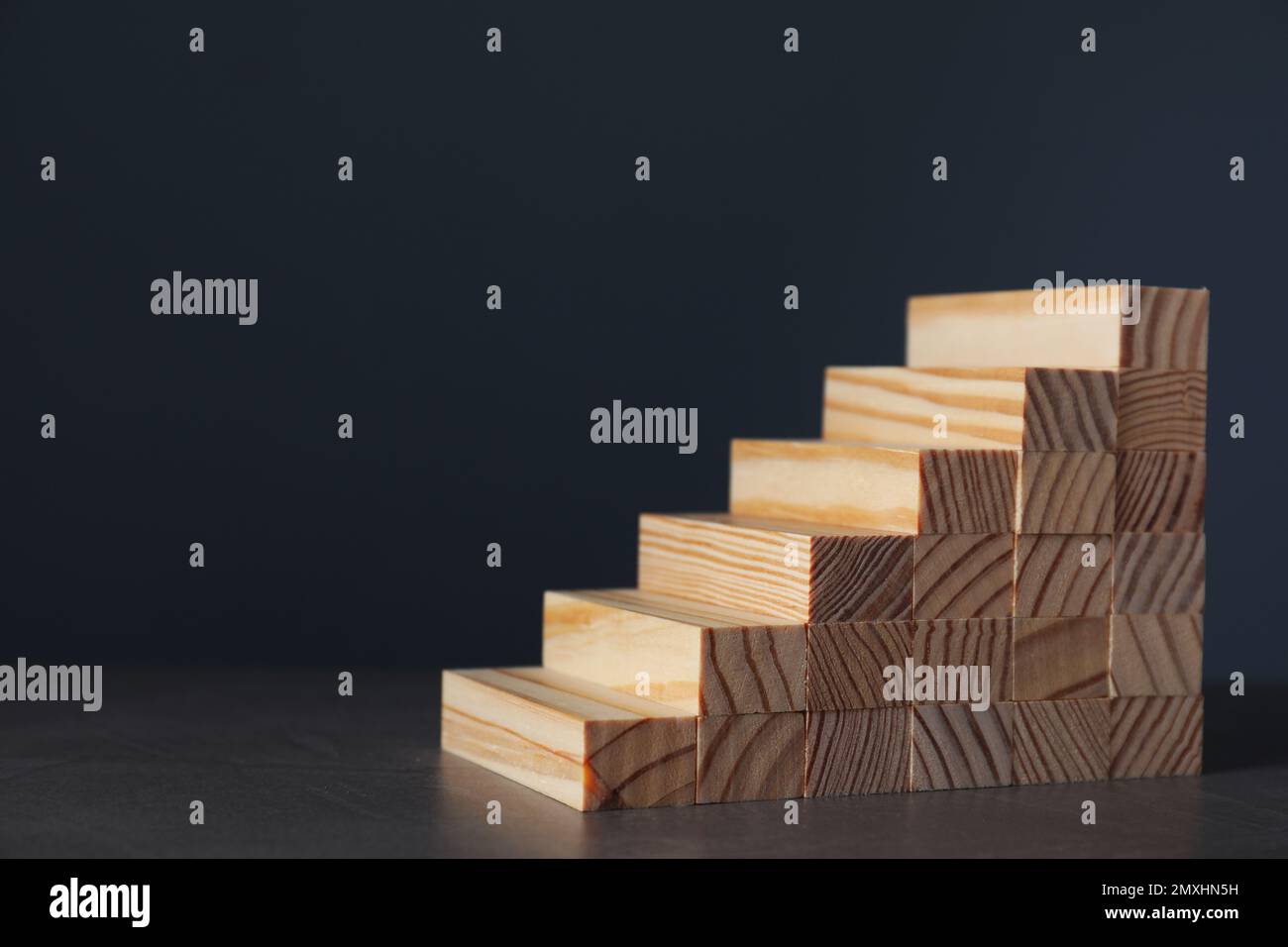 Steps made with wooden blocks on dark background, space for text ...