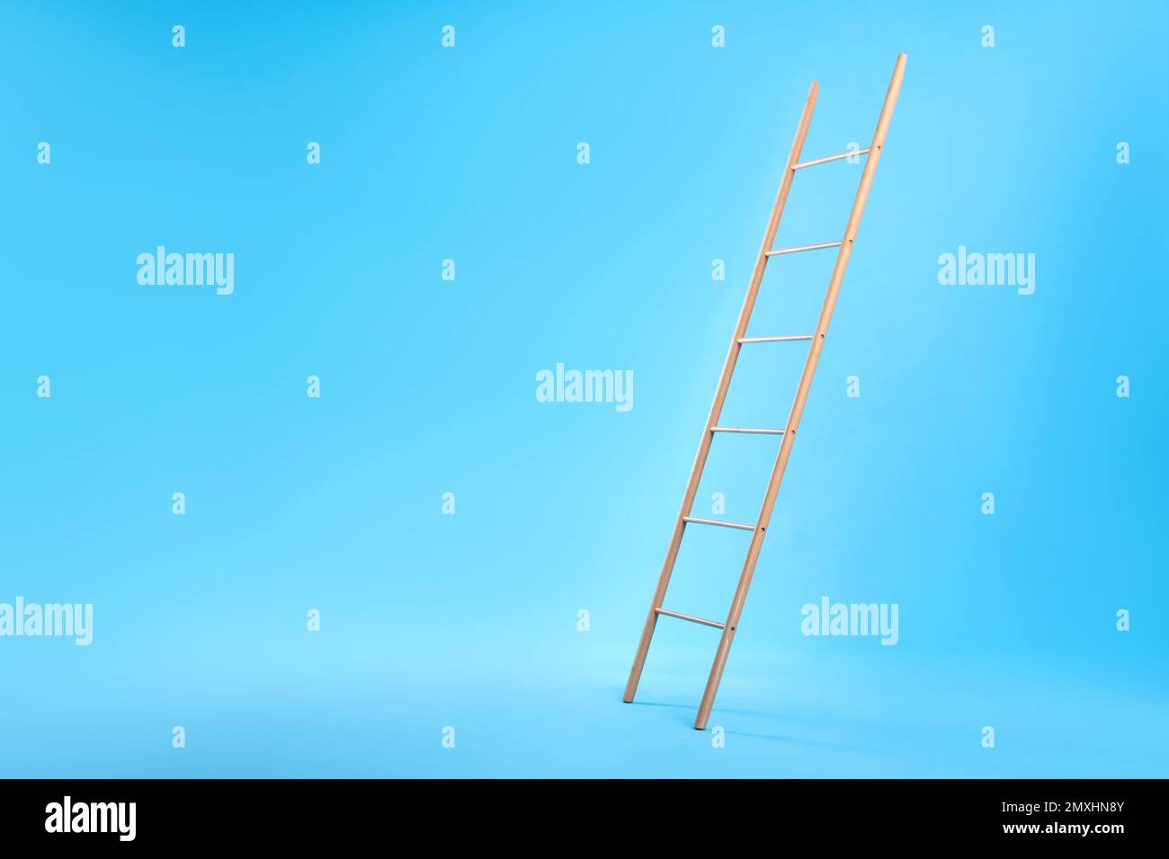 Modern wooden ladder on light blue background. Space for text Stock ...