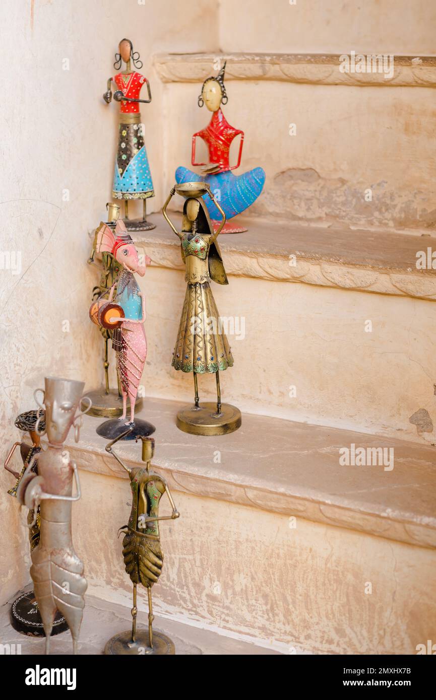 A vertical shot of metal stick figure dolls on the steps of a stair ...