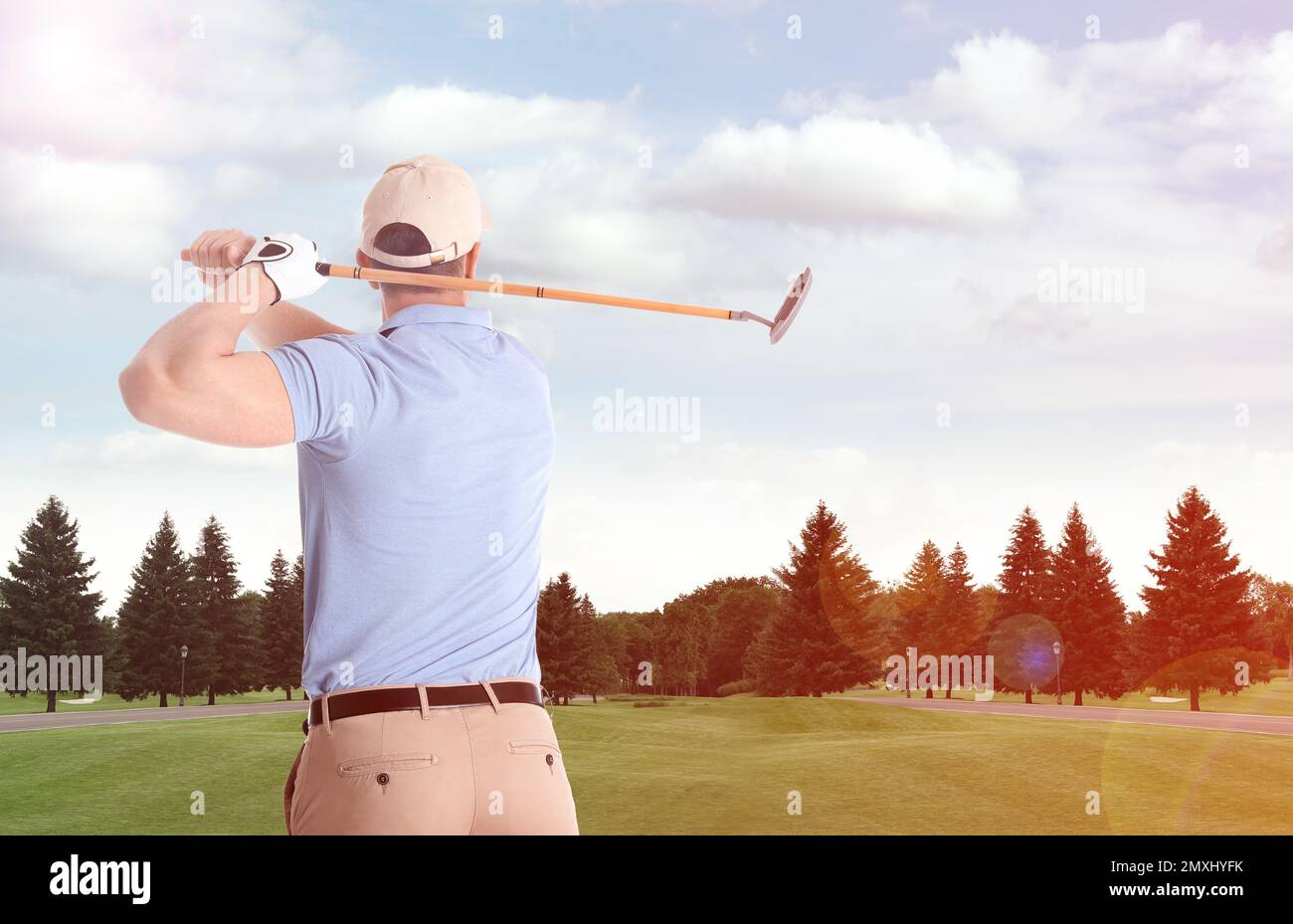 Young man playing golf on course with green grass, back view. Space for ...