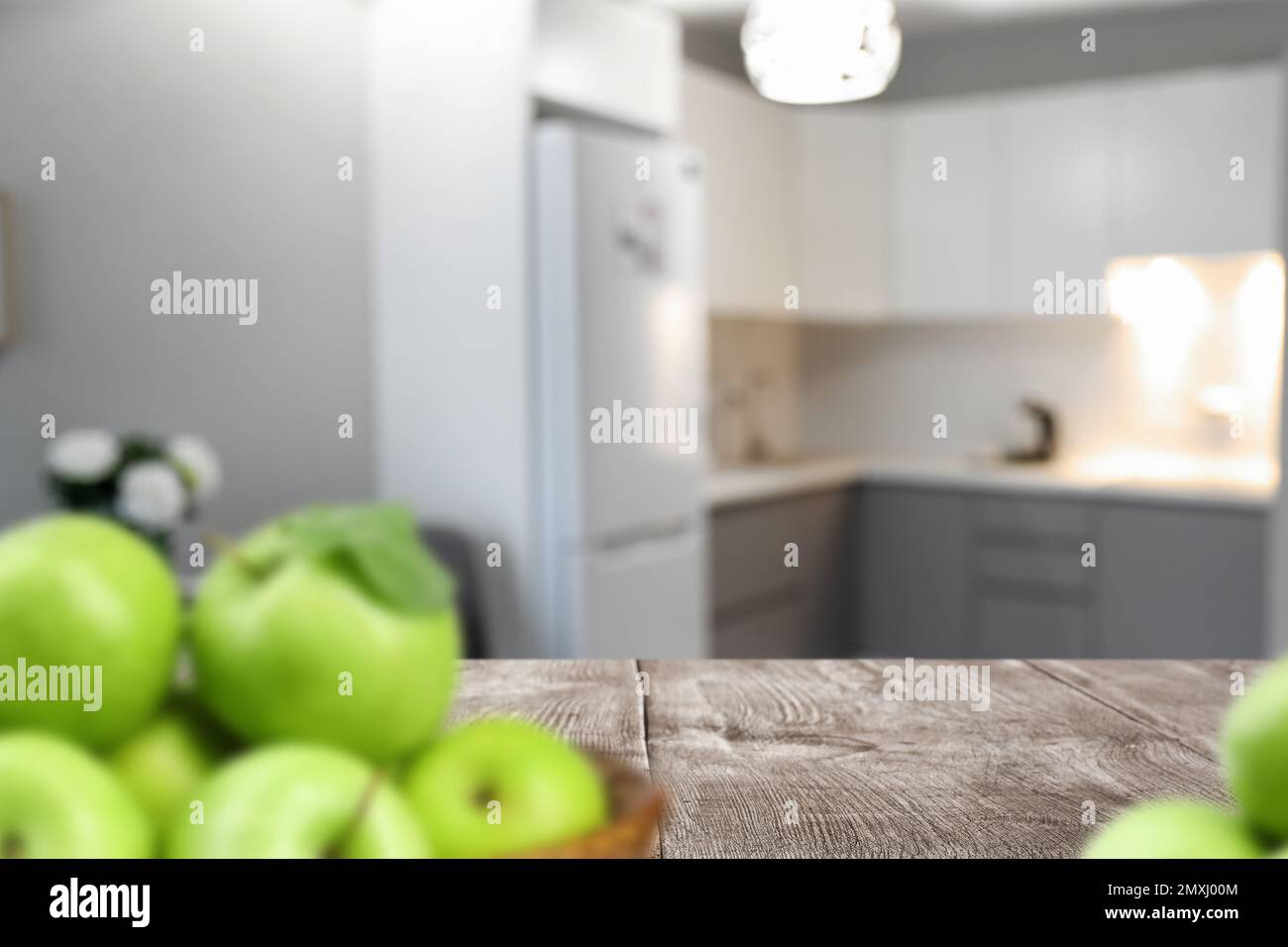 Wooden table with apples in modern kitchen interior Stock Photo - Alamy