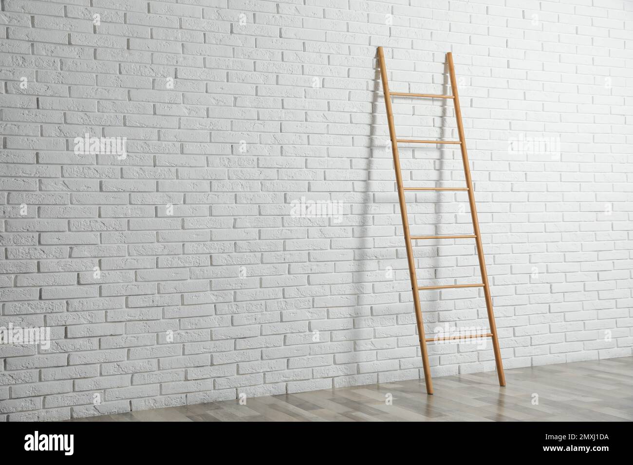 Modern wooden ladder near white brick wall. Space for text Stock Photo ...
