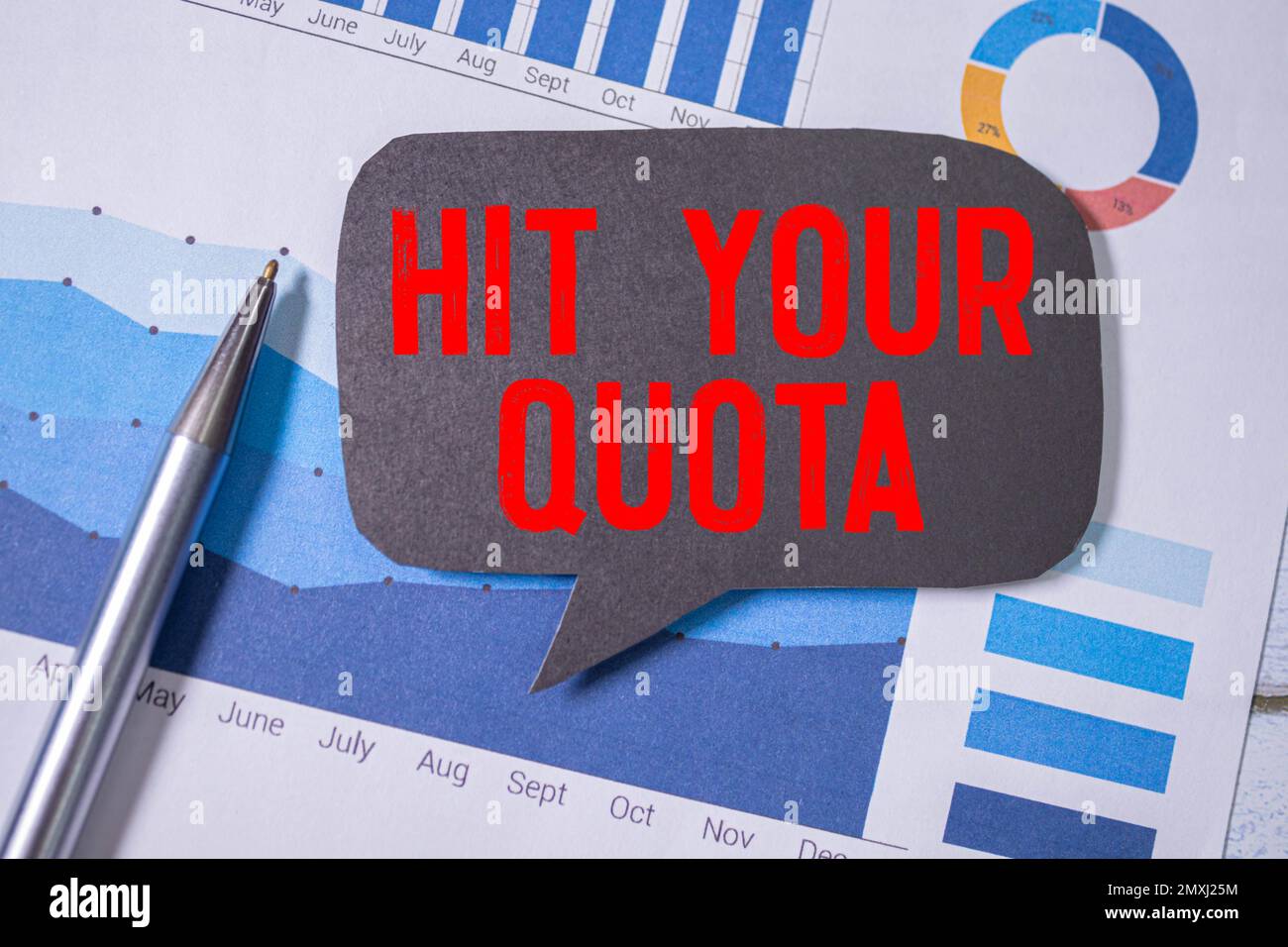 Closeup on businessman holding a card with text HIT YOUR QUOTA ...