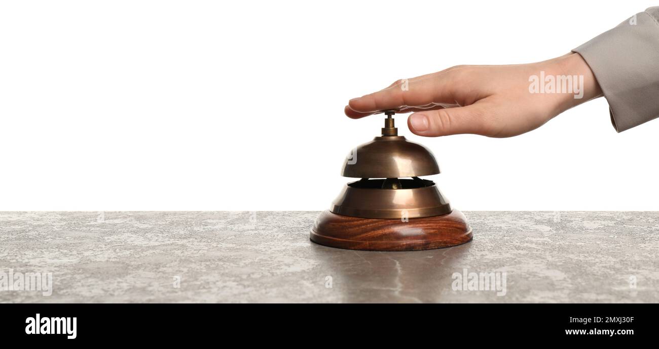 Woman ringing hotel service bell at grey stone table Stock Photo - Alamy