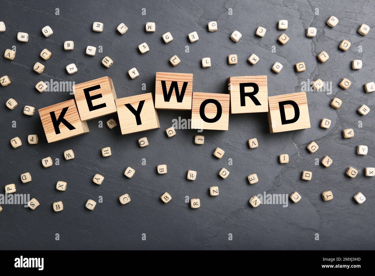 Wooden cubes with word KEYWORD and beads on dark grey background, flat ...