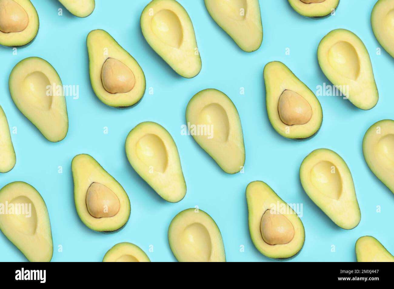 Flat lay composition with fresh ripe avocados on light blue background ...