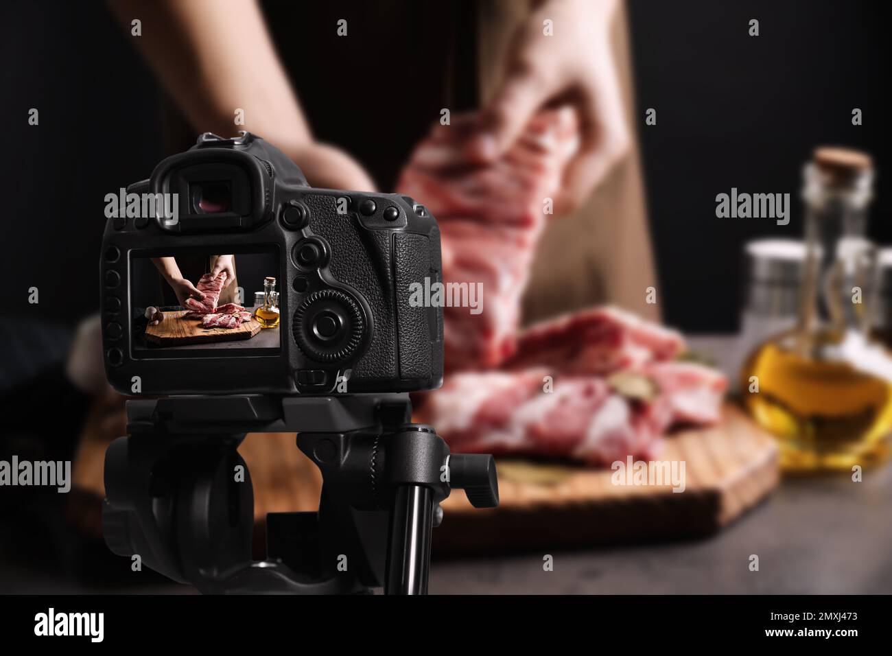Food photography. Shooting of man holding raw ribs, focus on camera ...