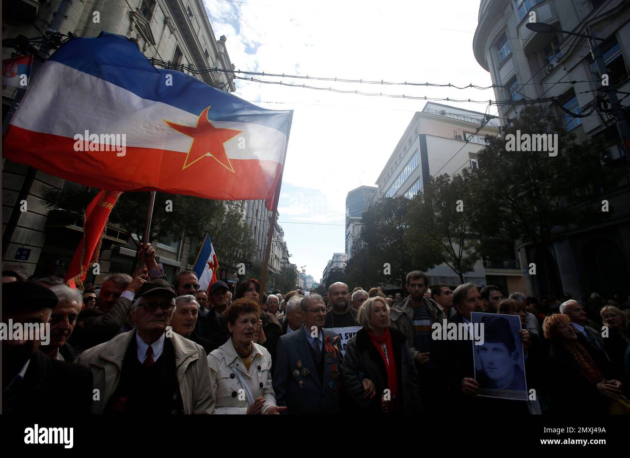 People wave an old Yugoslav communist flag during a ceremony in ...