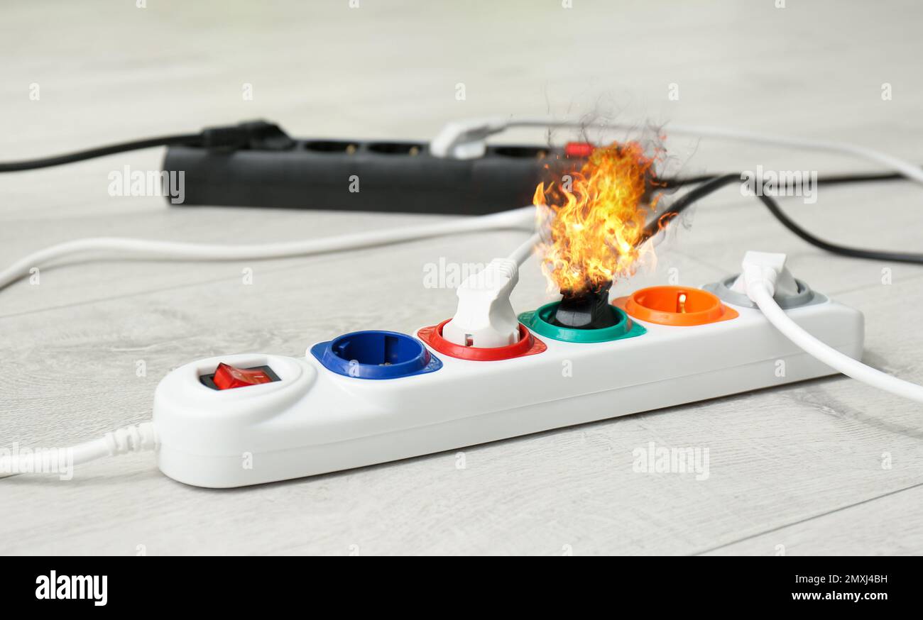 Inflamed plug in power board - result of electrical short circuit Stock ...