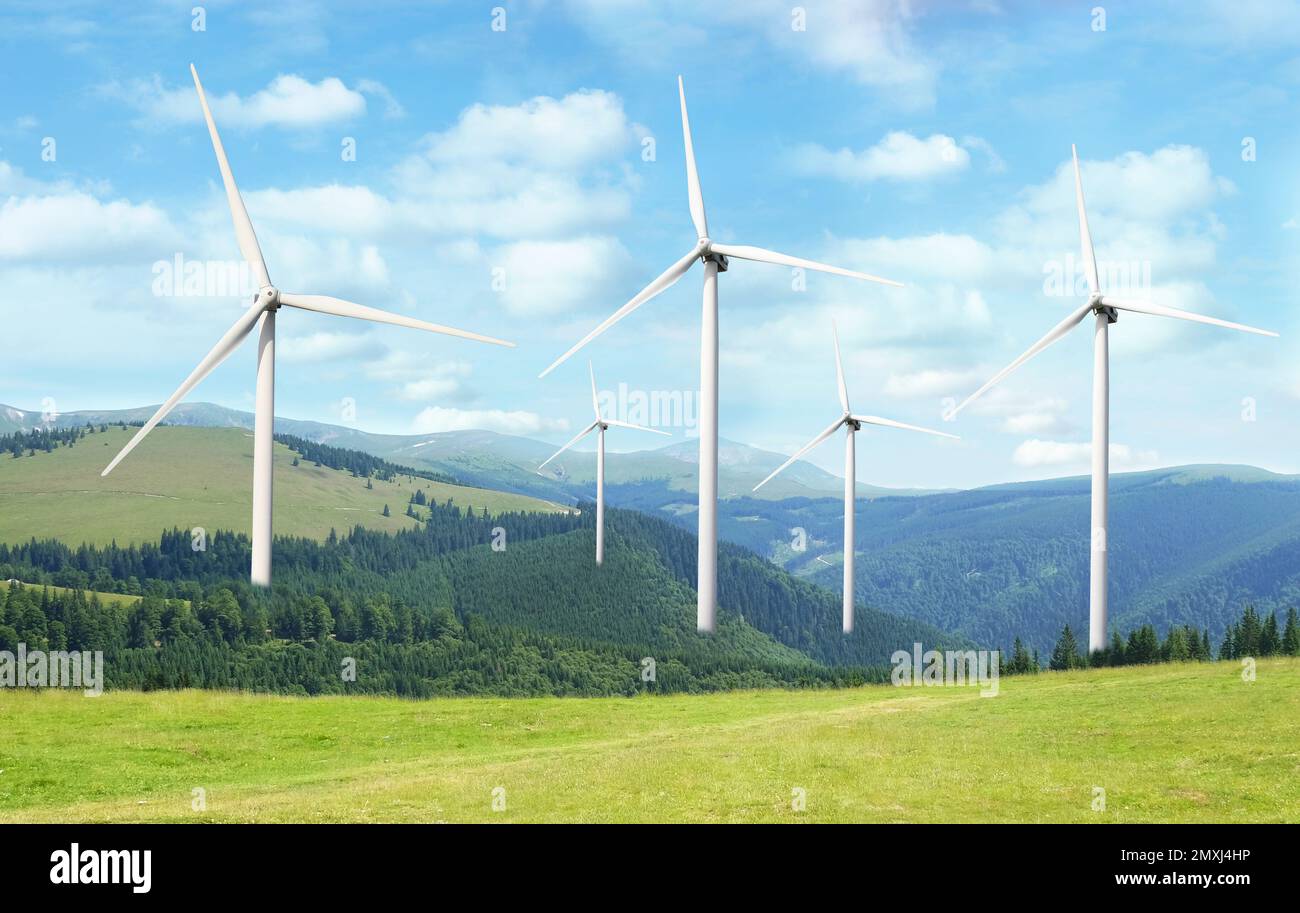Alternative energy source. Wind turbines in mountains under blue sky ...