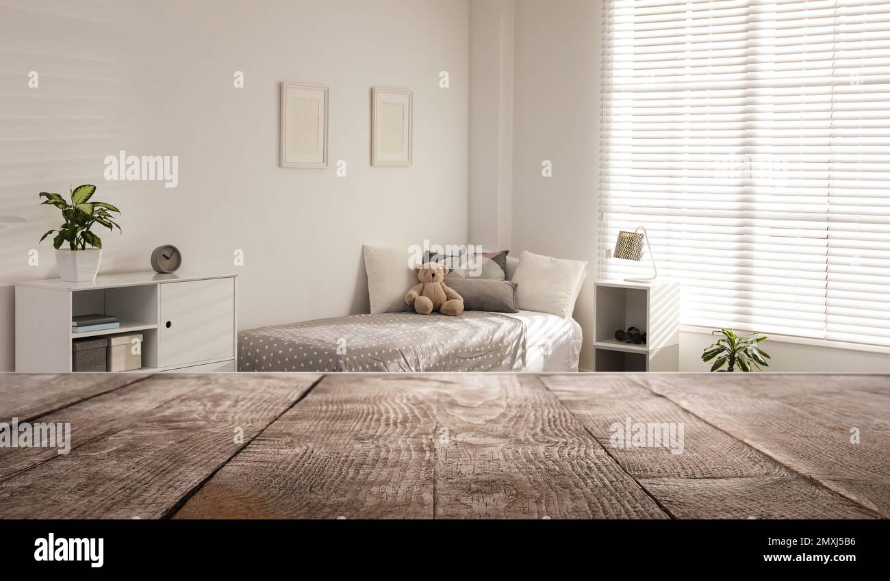 Empty wooden table in baby room interior Stock Photo - Alamy