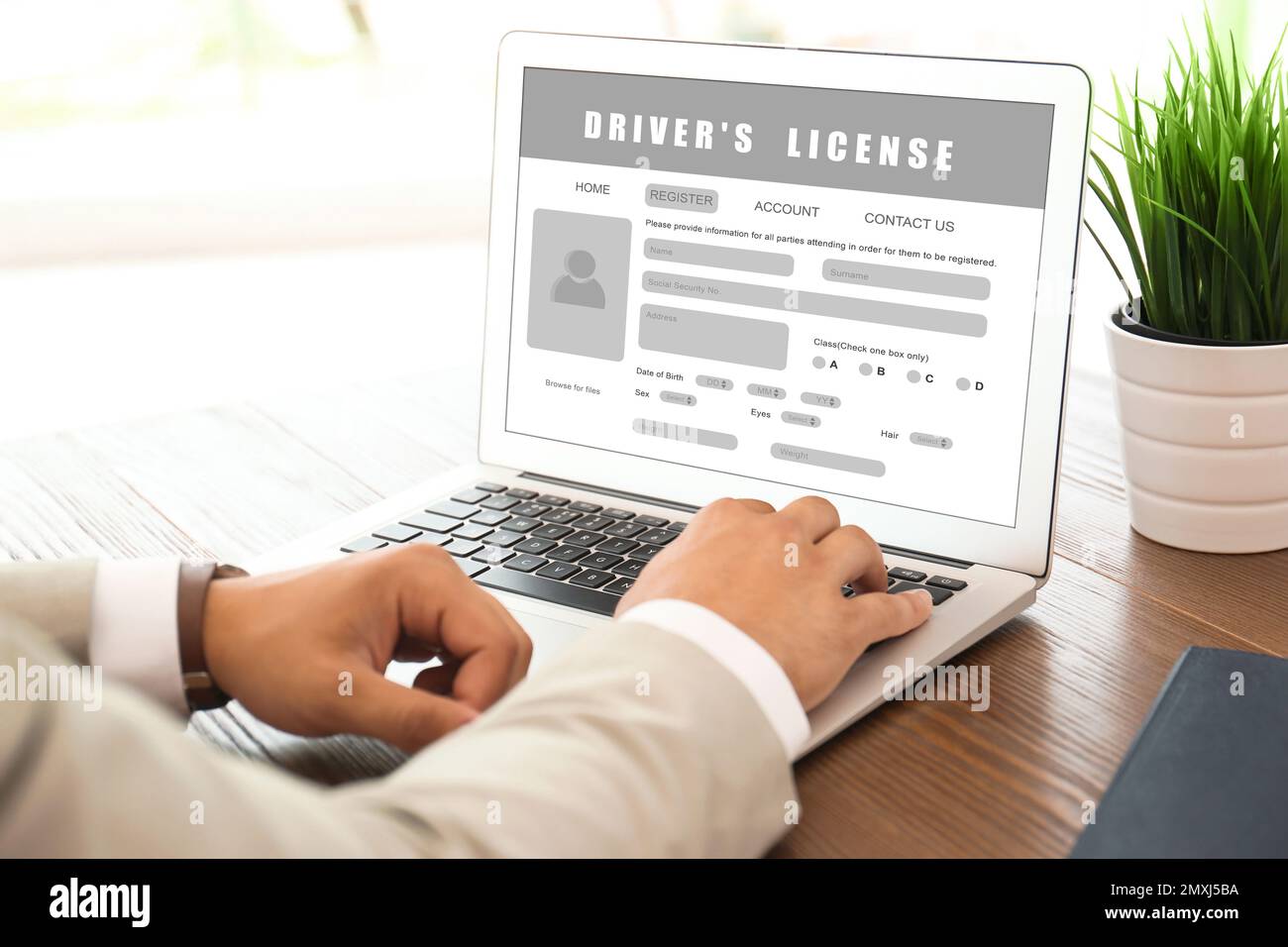 Man filling in driver's license form online on website using laptop ...