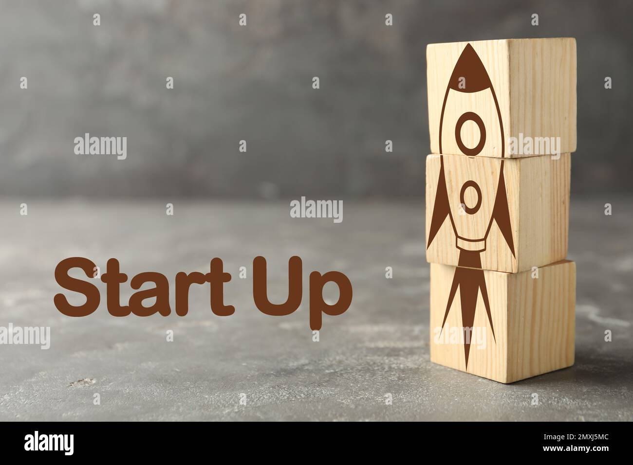 Rocket made of wooden cubes and text START UP on grey background Stock ...
