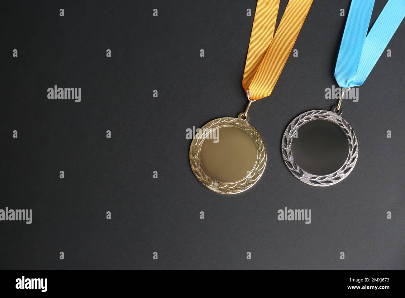 Gold and silver medals on black background, flat lay. Space for design ...