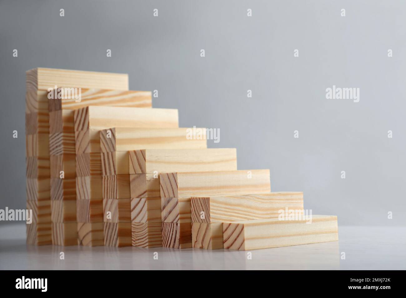 Steps made with wooden blocks on light background, space for text ...