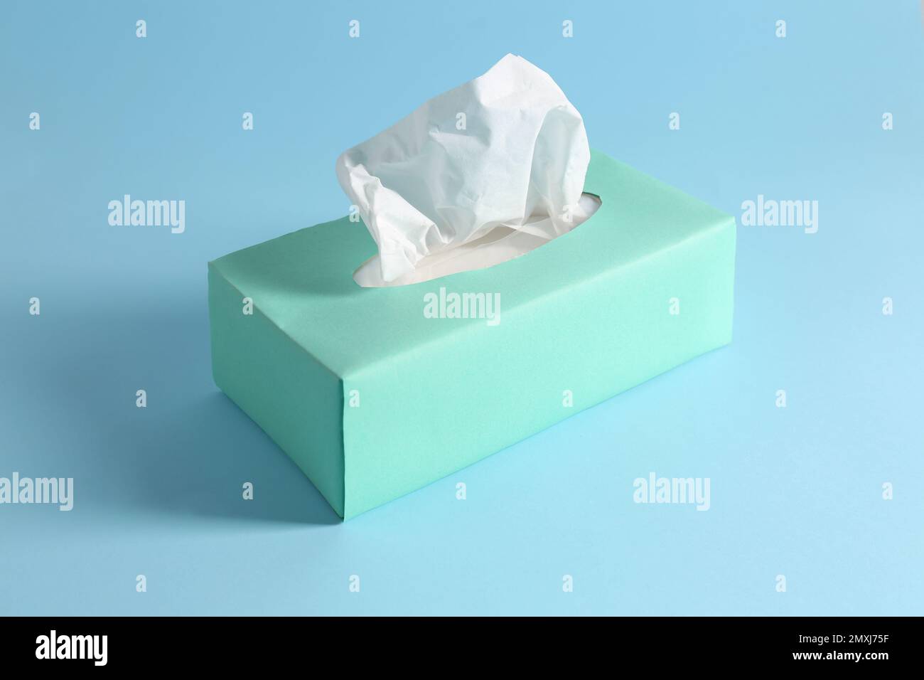 Box of paper tissues on light blue background Stock Photo - Alamy