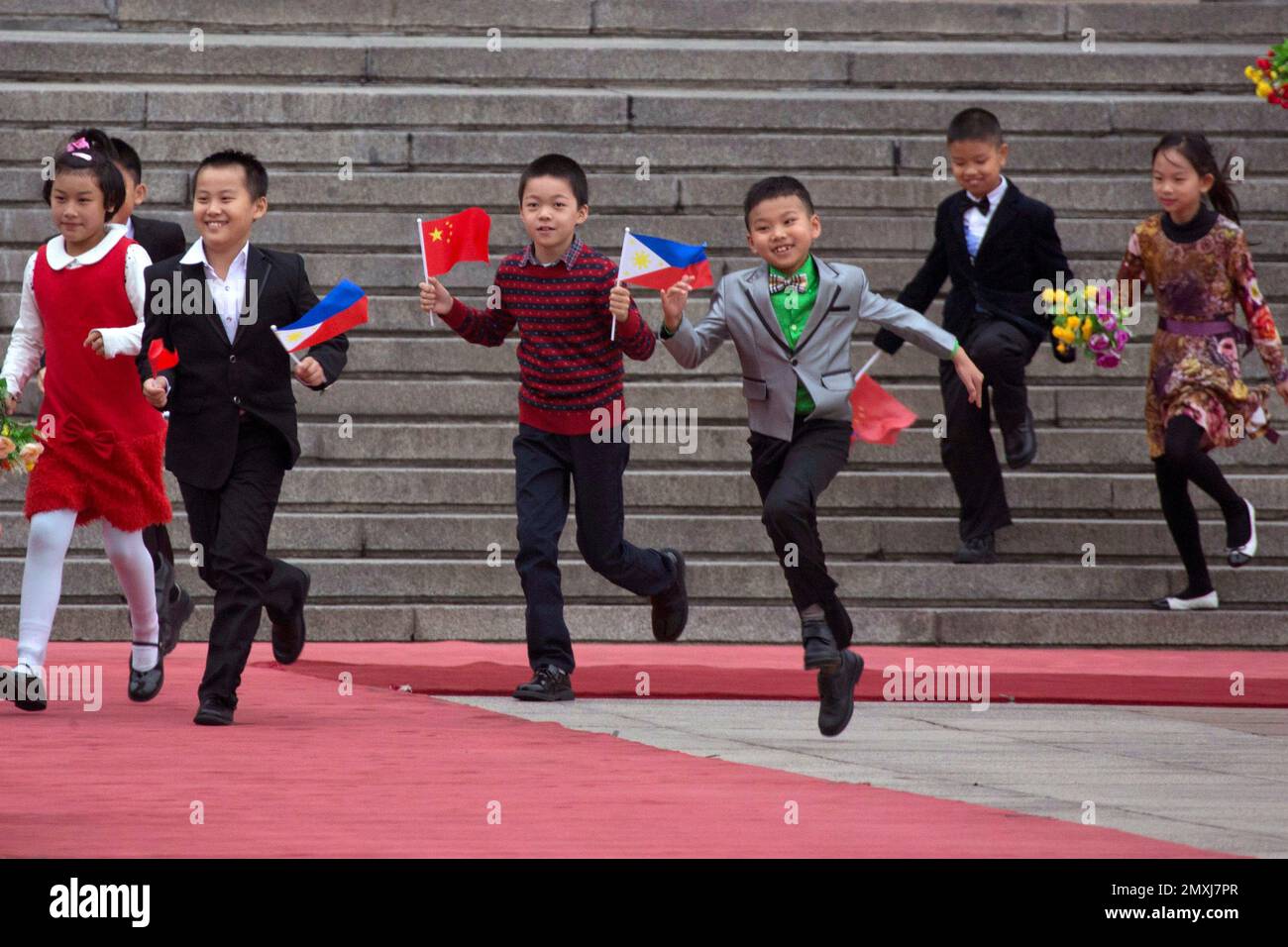 Chinese children holding flags and flowers prepare for a welcome ...