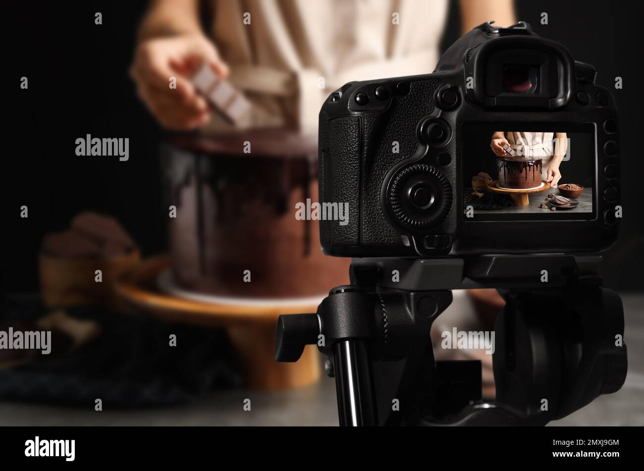 Food photography. Shooting of chef decorating chocolate cake, focus on ...