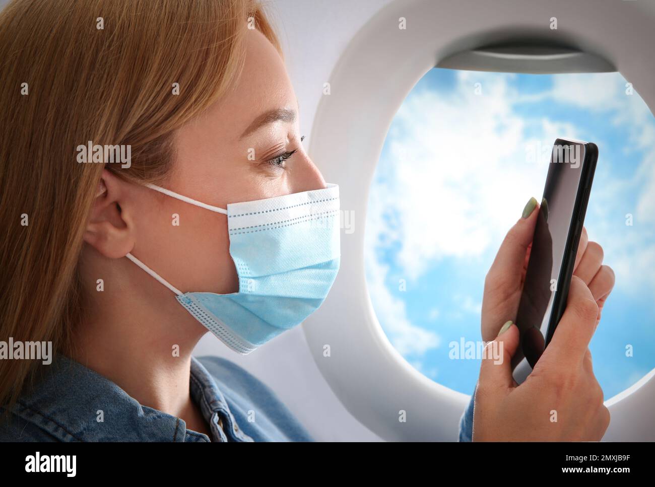 Traveling by airplane during coronavirus pandemic. Woman with face mask ...