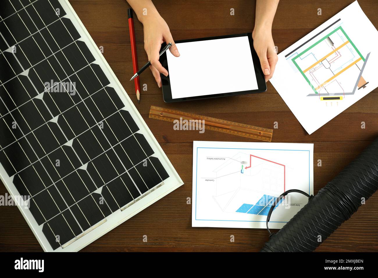 Architect working on house project with solar panels at wooden table ...
