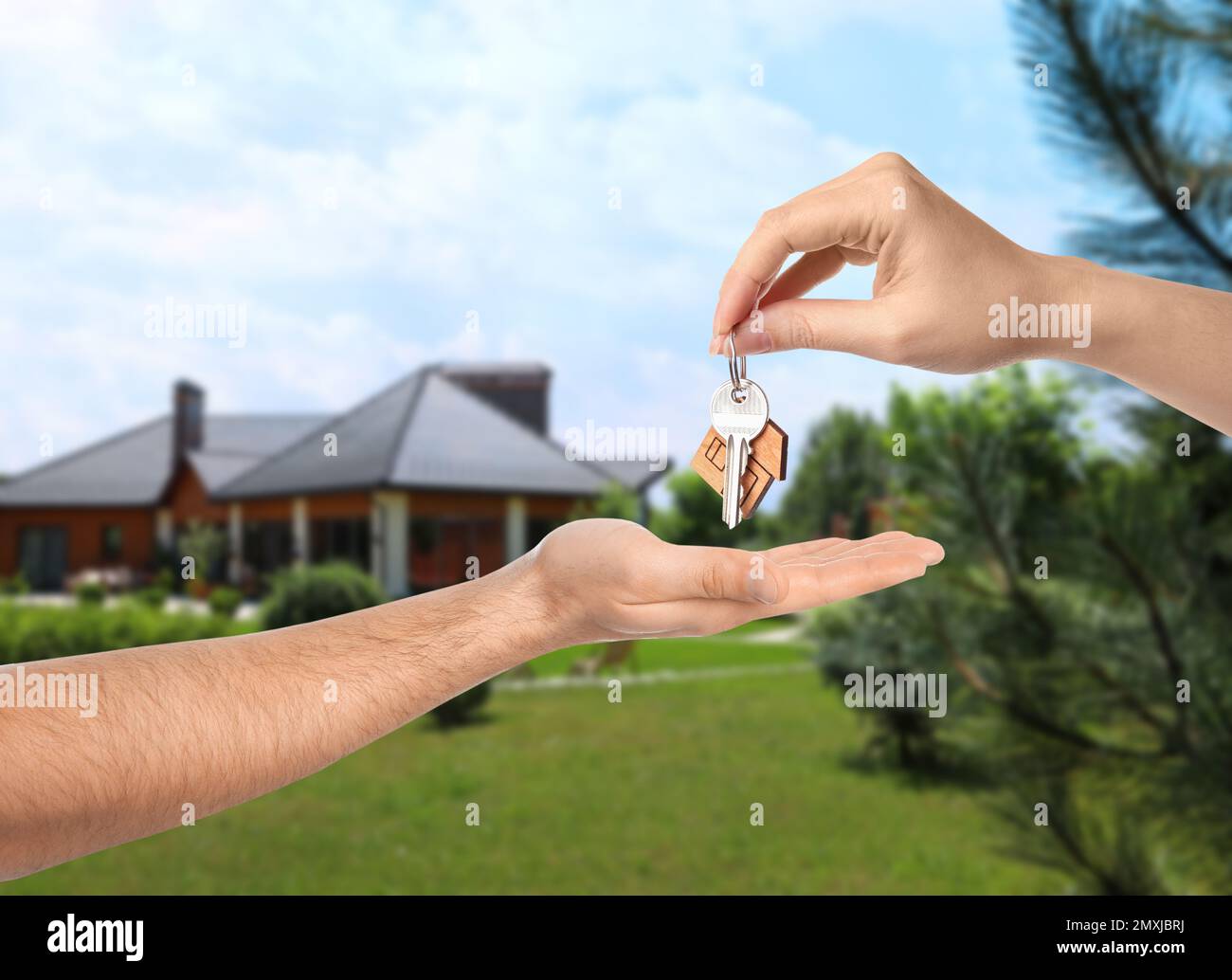 Real estate agent giving key to man against modern house, closeup Stock ...